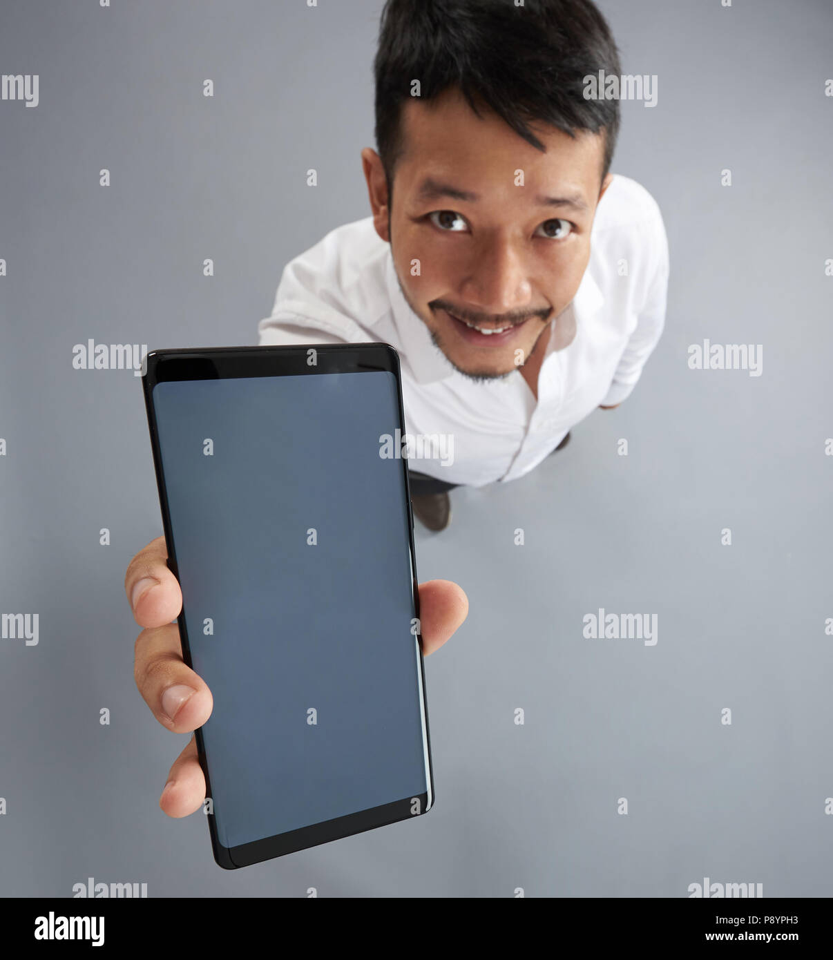 Young asian man holding smartphone hi-res stock photography and images ...