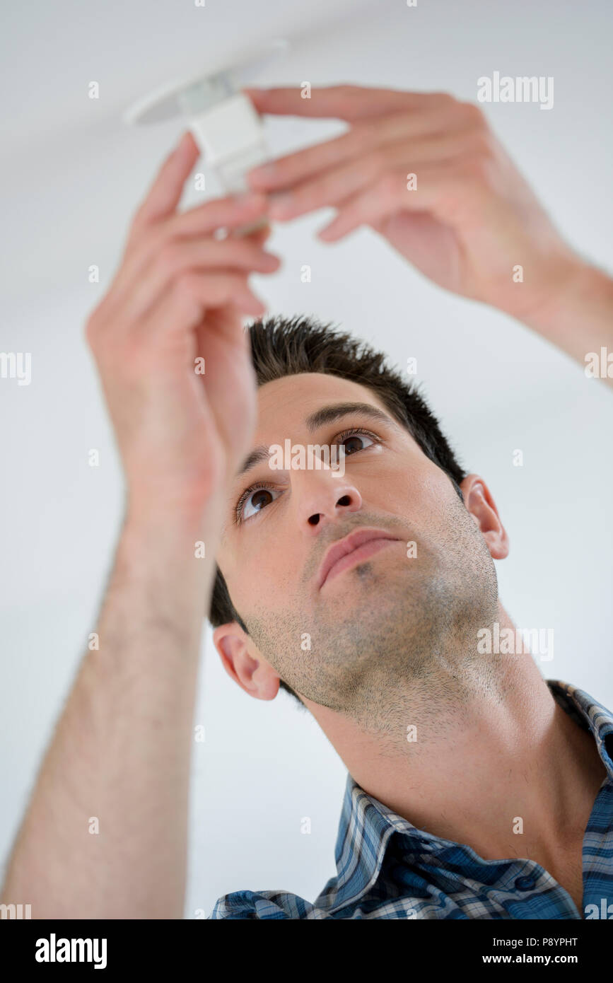 man attaching light on the ceiling Stock Photo - Alamy