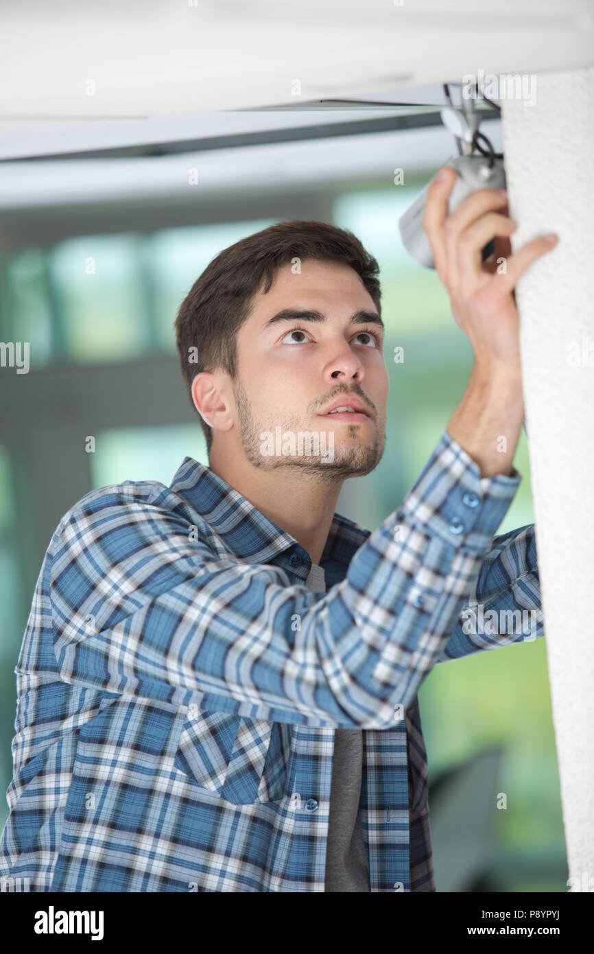 Young worker fitting cctv camera Stock Photo - Alamy