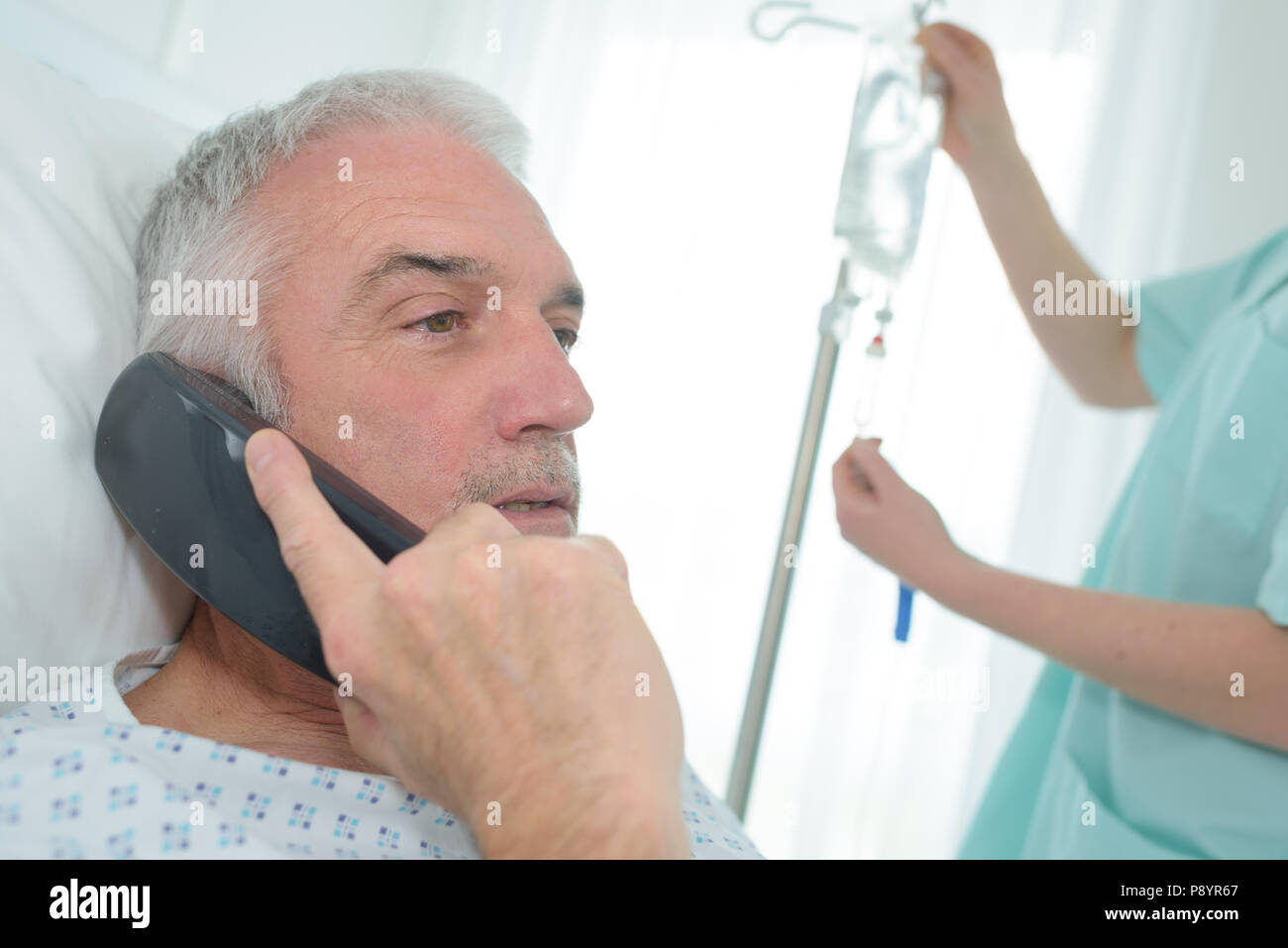 male patient using mobile phone in hospital bed Stock Photo - Alamy