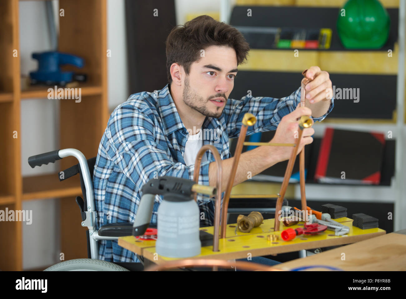 Disabled plumber working on copper pipes Stock Photo - Alamy