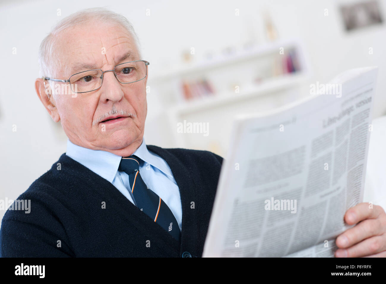 elderly man reading at a newspaper Stock Photo - Alamy