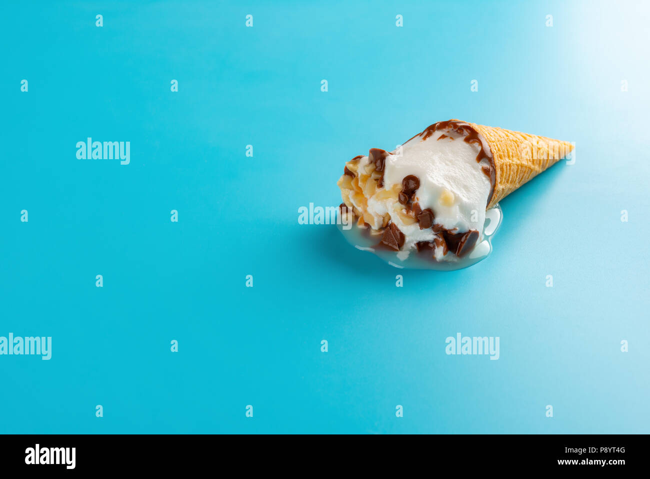 mini Vanilla flavor ice cream cone in a melting process on blue ...