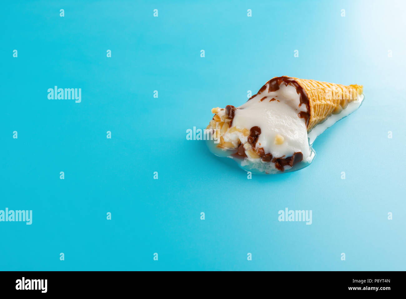 mini Vanilla flavor ice cream cone in a melting process on blue ...