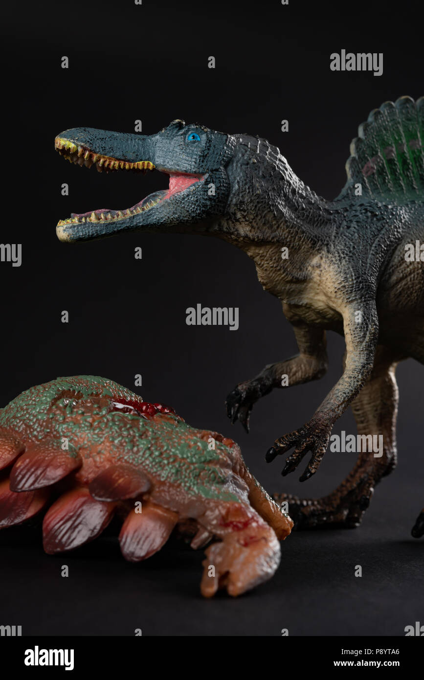 spinosaurus with a stegosaurus body nearby on dark background vertical ...