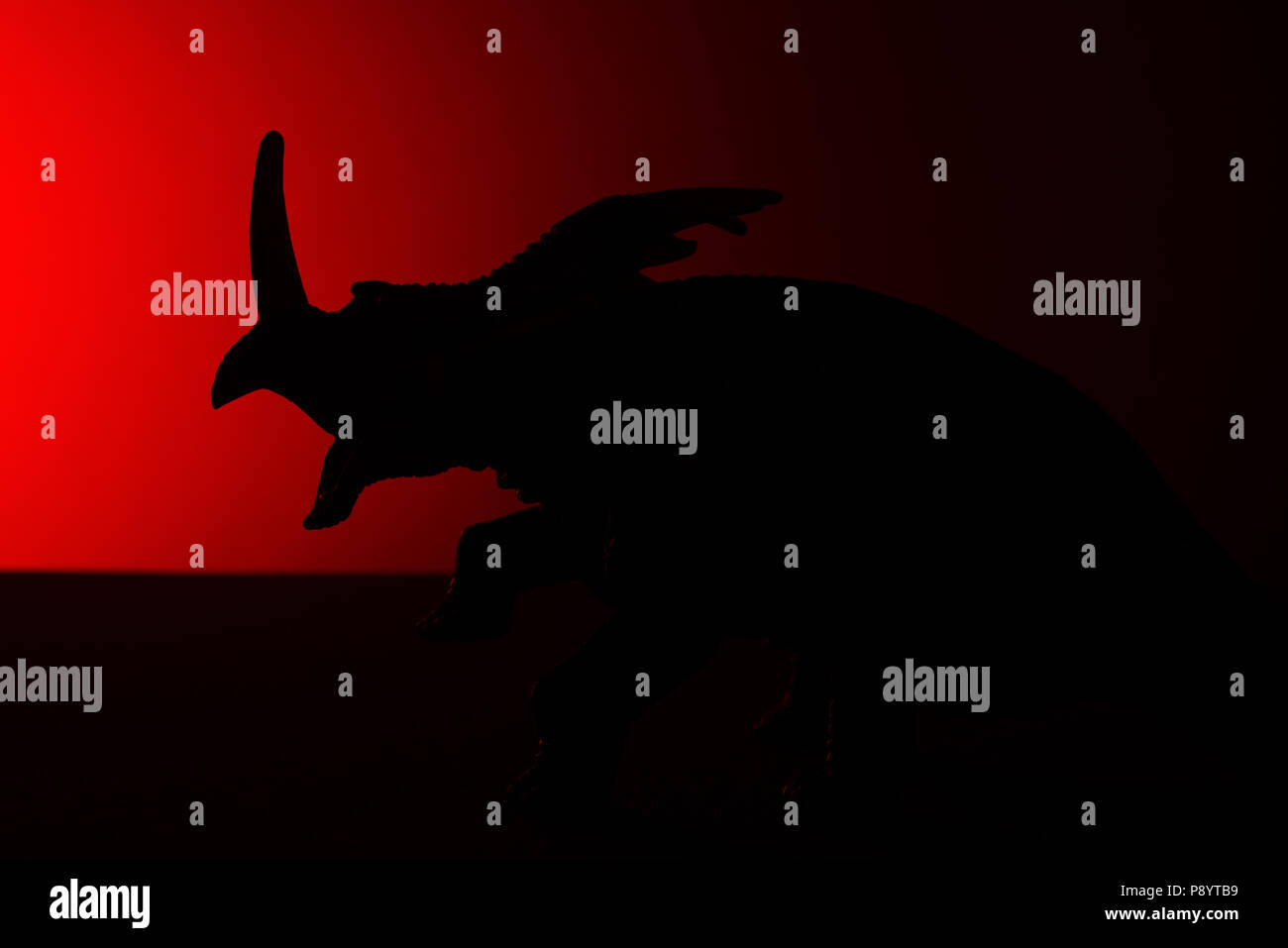 triceratops shadow with red light in dark Stock Photo - Alamy