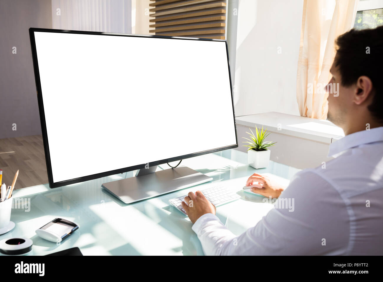 Businessman using computer with blank white screen Stock Photo - Alamy