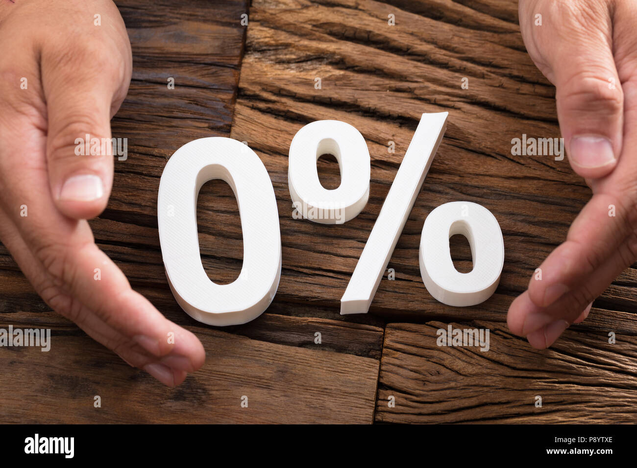 Close-up of a businessperson's hand protecting white zero percentage ...