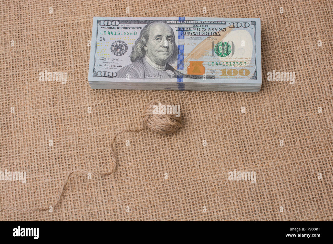 Spool of linen spool is placed on bundle of US dollar banknotes Stock ...