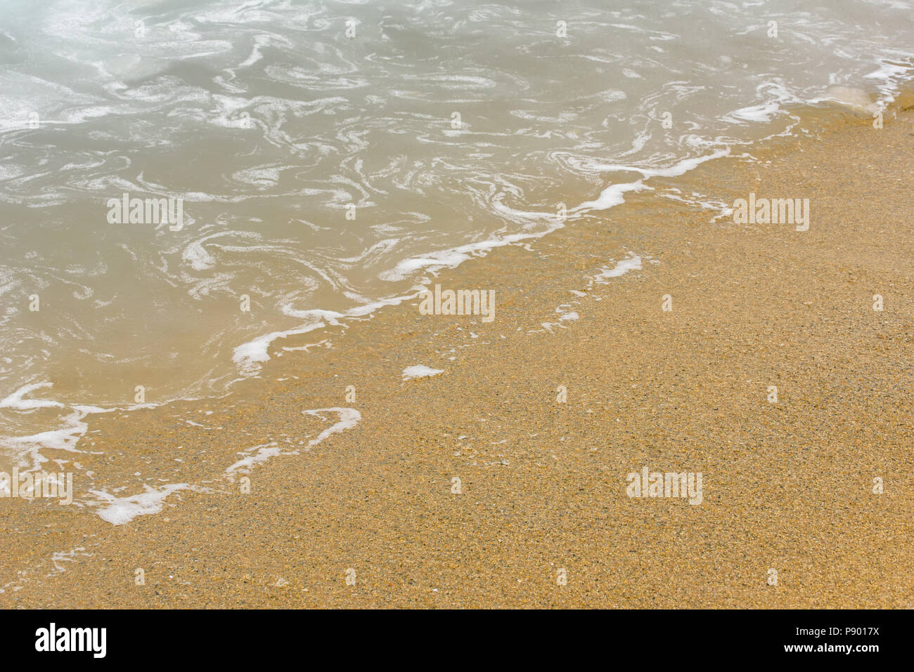 Sand and water. Wave of blue ocean on sandy beach Stock Photo - Alamy
