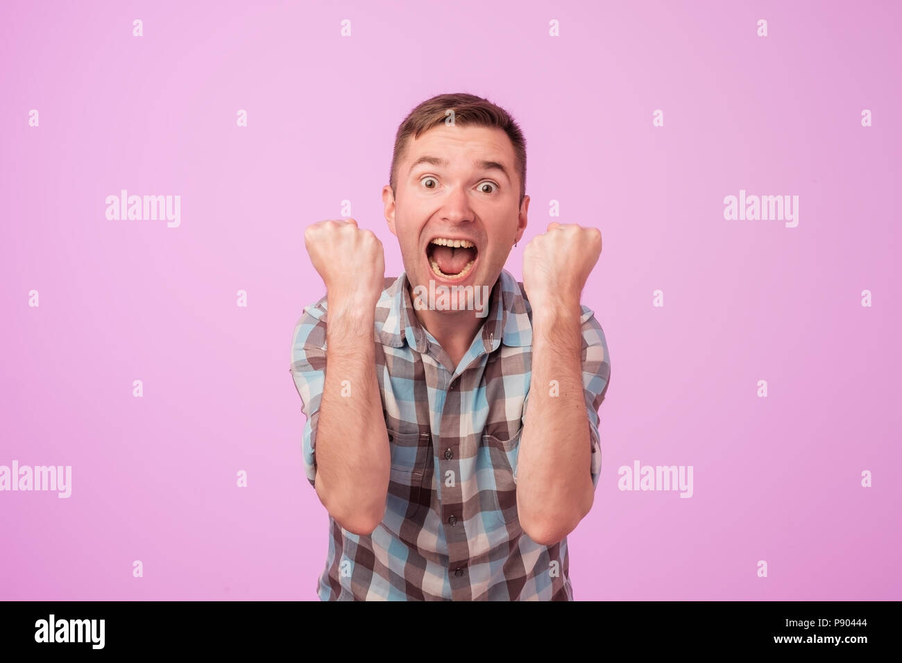 Portrait of young european man with overjoyed facial expression on pink ...