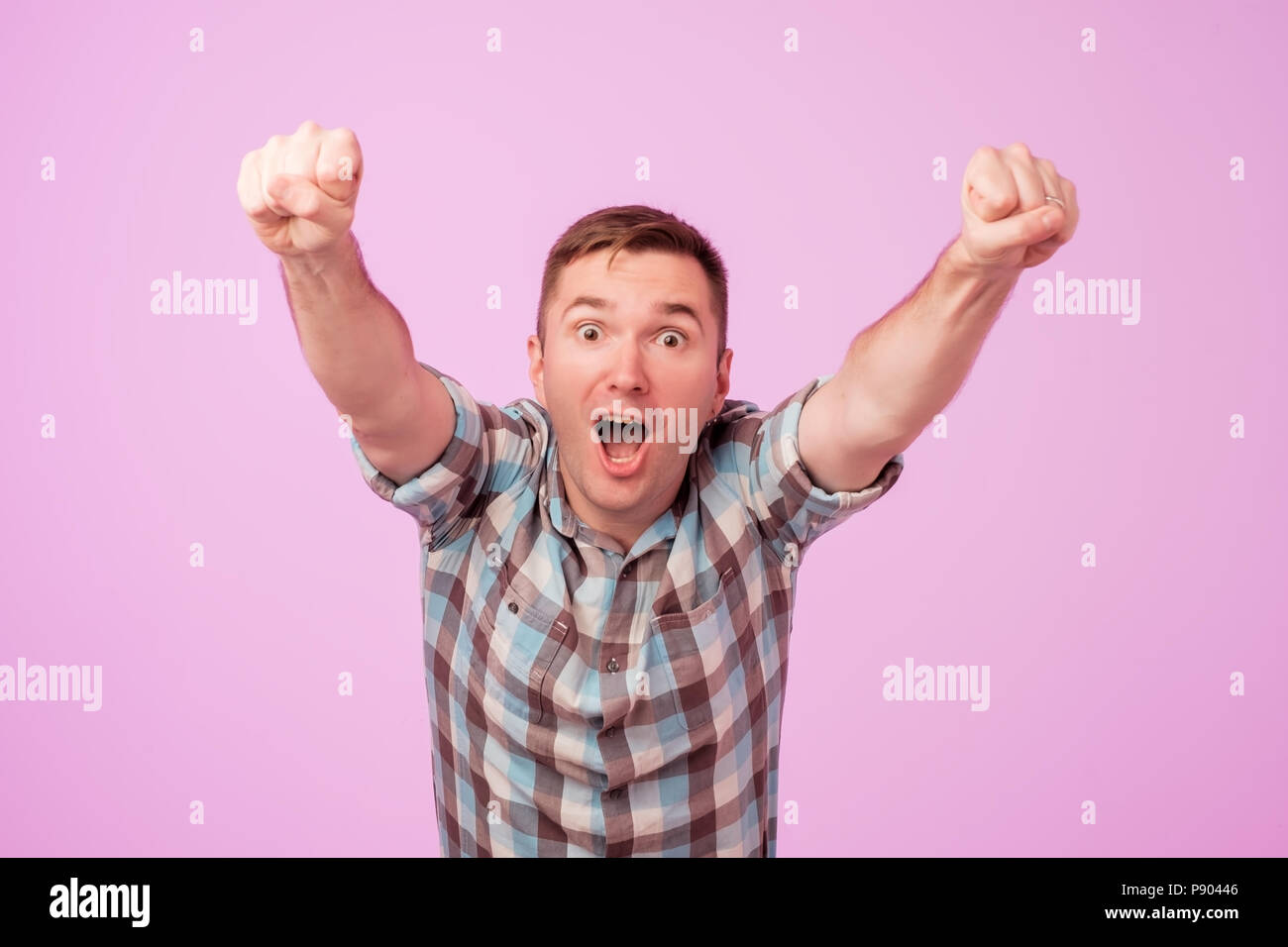 Portrait of young european man with overjoyed facial expression on pink ...