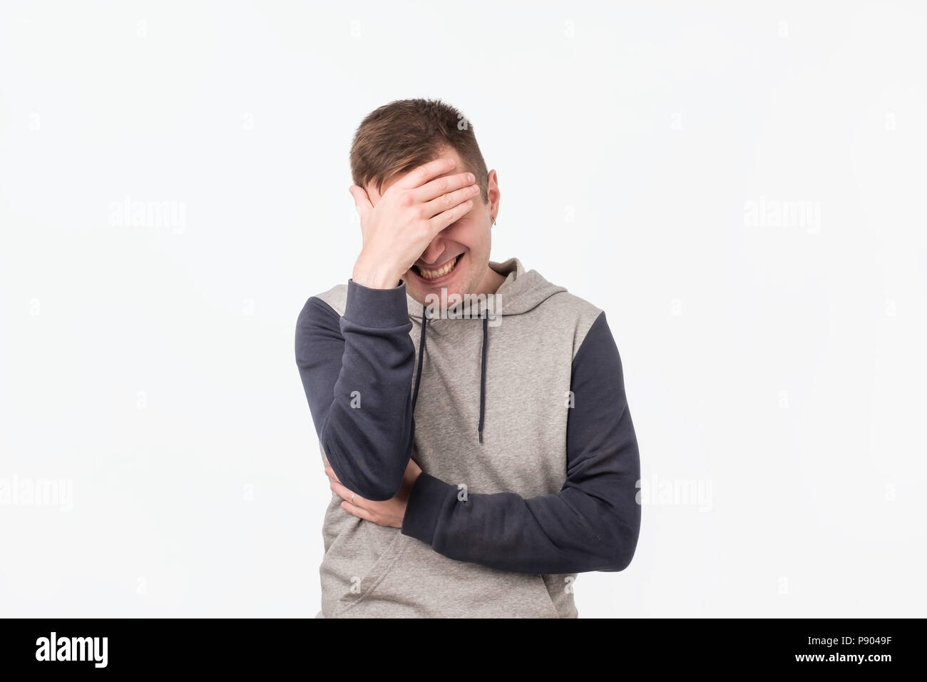 Portrait of glad attractive man laughs happily at funny story or joke ...