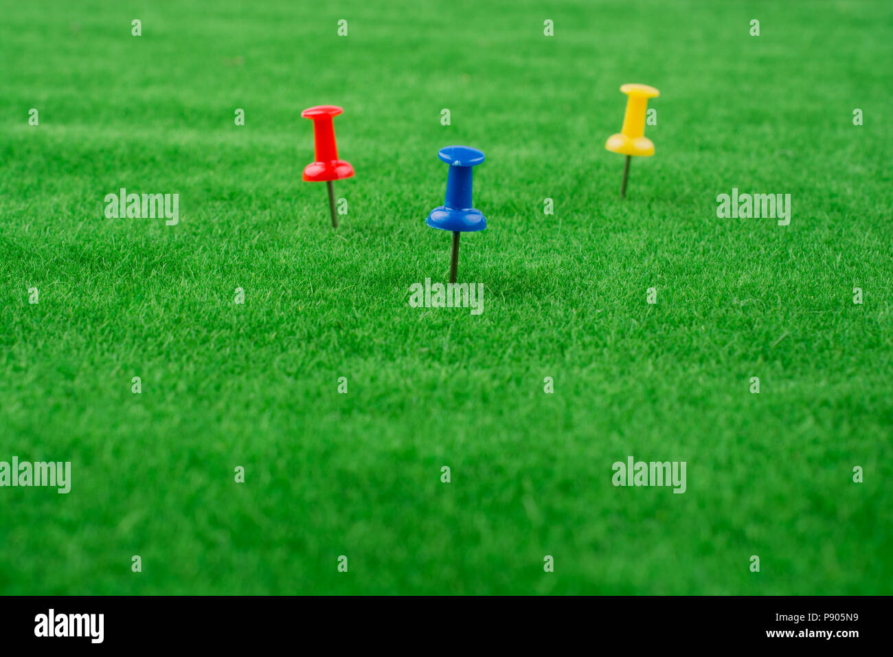 Colorful pins on green grass Stock Photo - Alamy