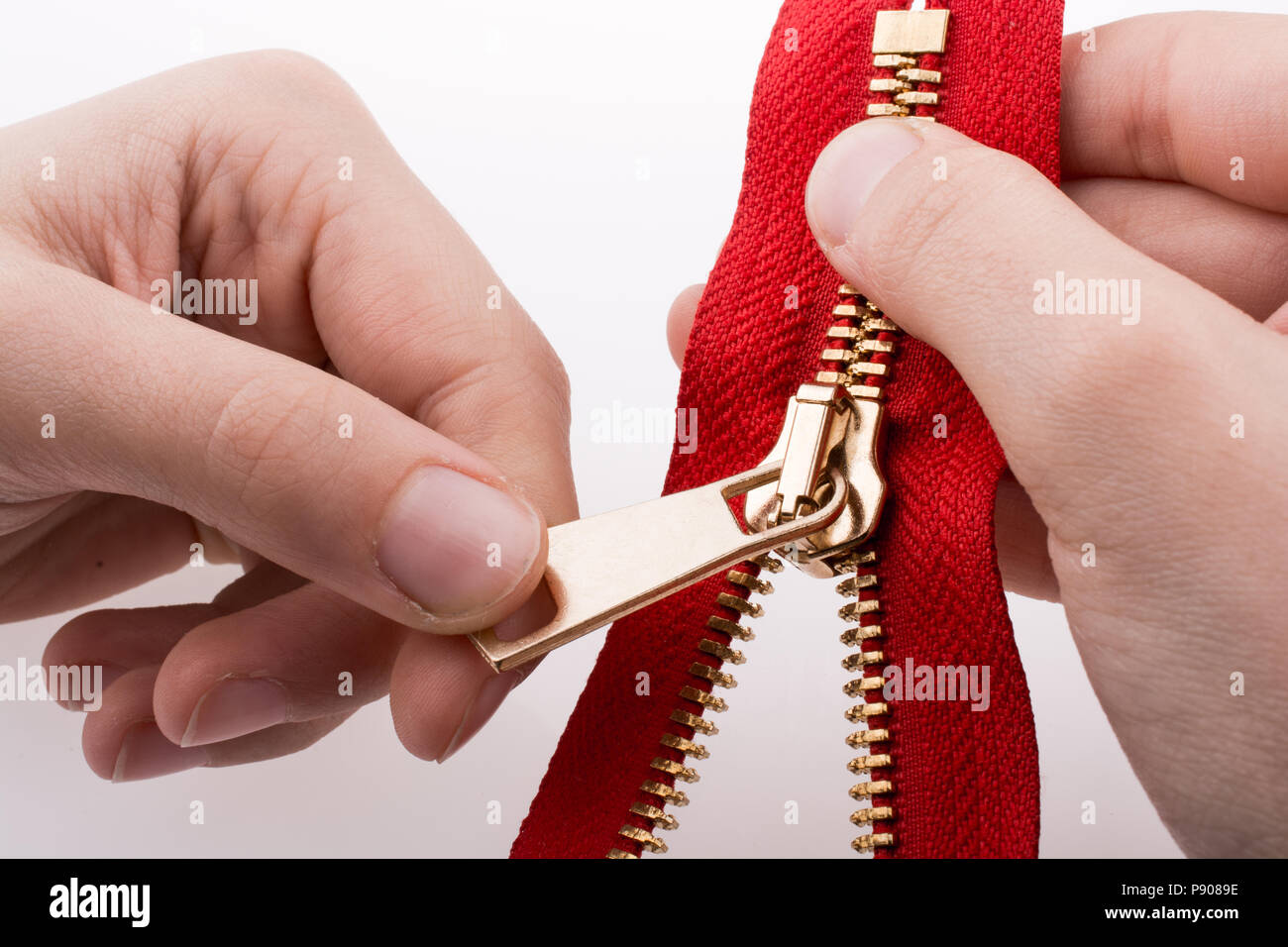 Hand holding color zipper on a white background Stock Photo - Alamy