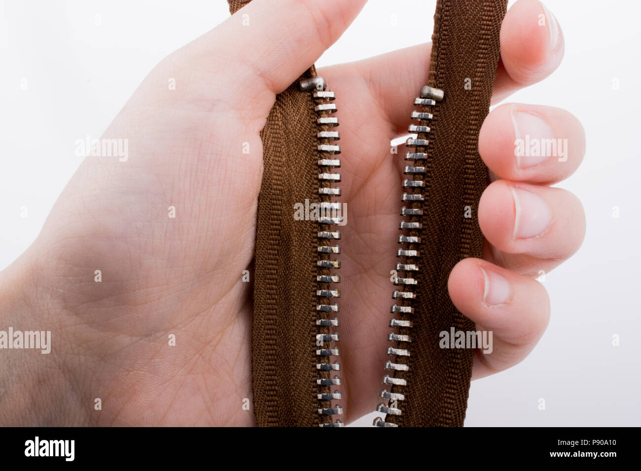 Hand holding color zipper on a white background Stock Photo - Alamy