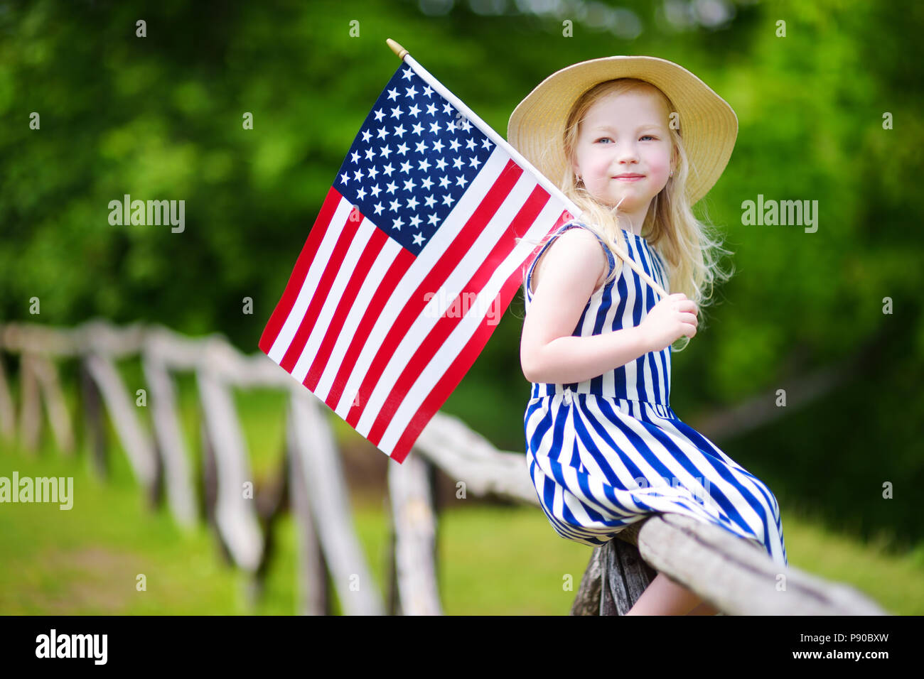 Adorable little girl wearing hat holding american flag outdoors on ...