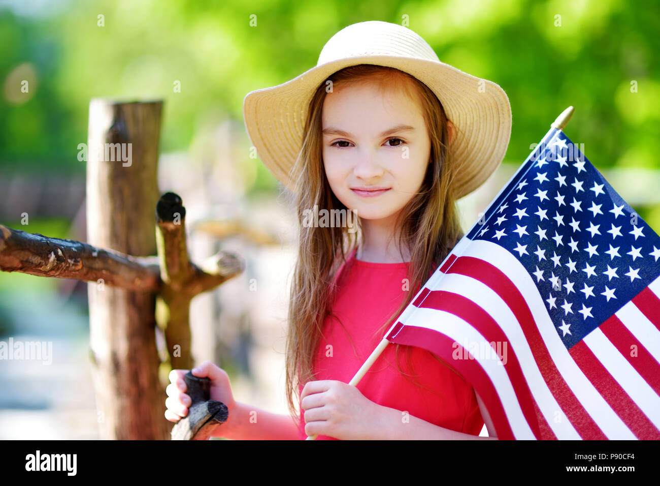 Adorable little girl holding american flag outdoors on beautiful summer ...