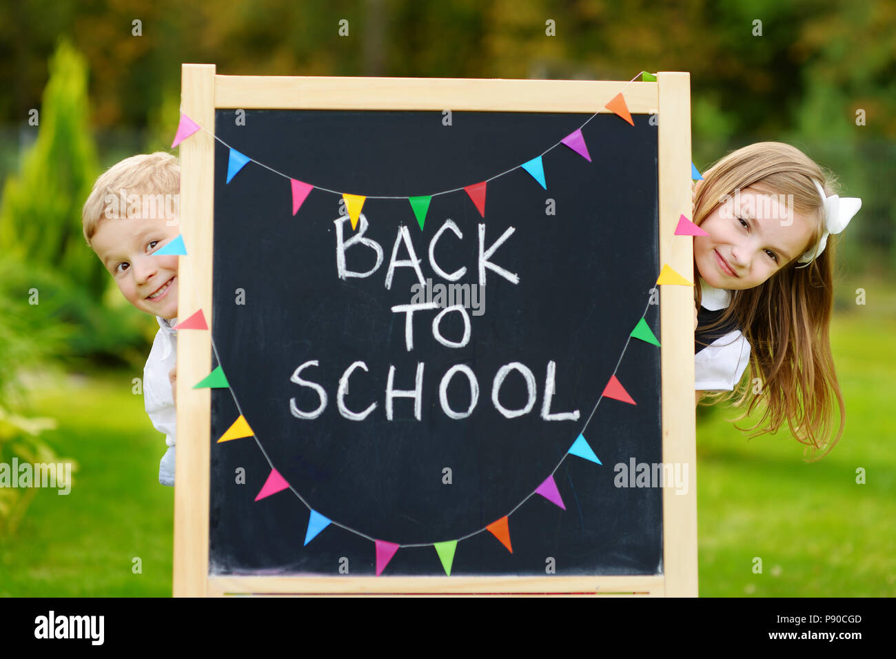 Two adorable little schoolkids feeling very excited about going back to ...