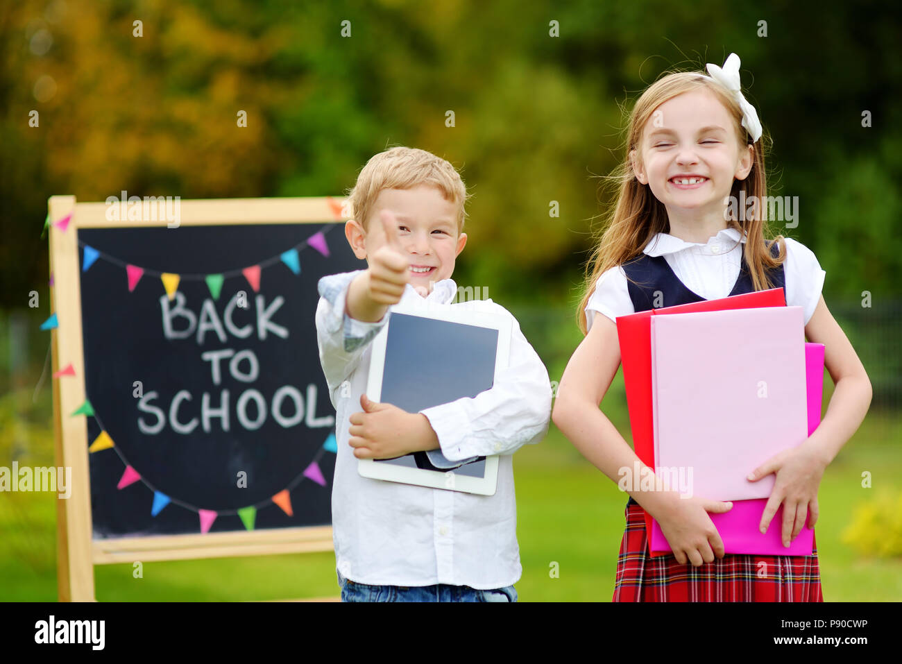Two adorable little schoolkids feeling very excited about going back to ...