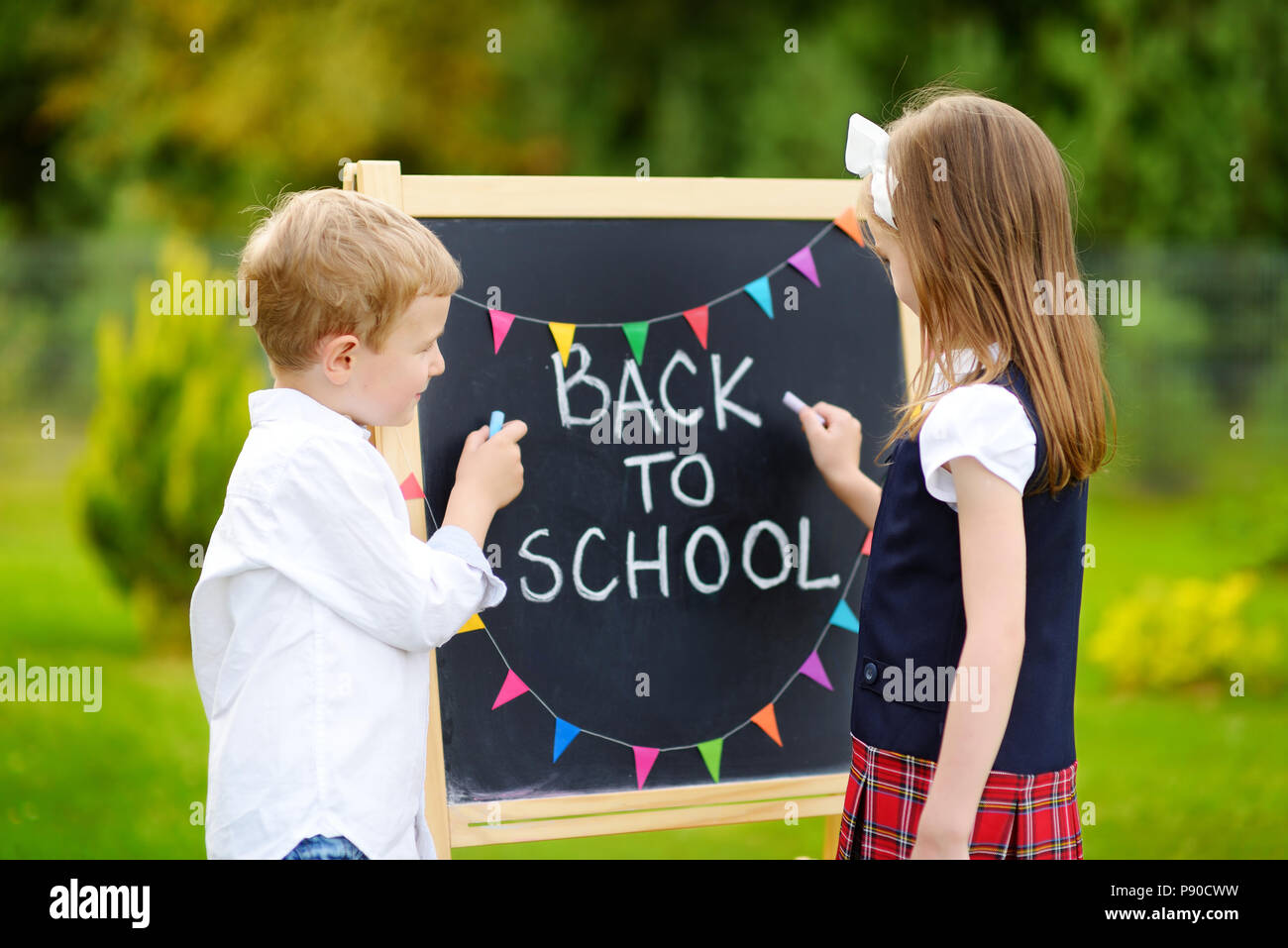 Two adorable little schoolkids feeling very excited about going back to ...