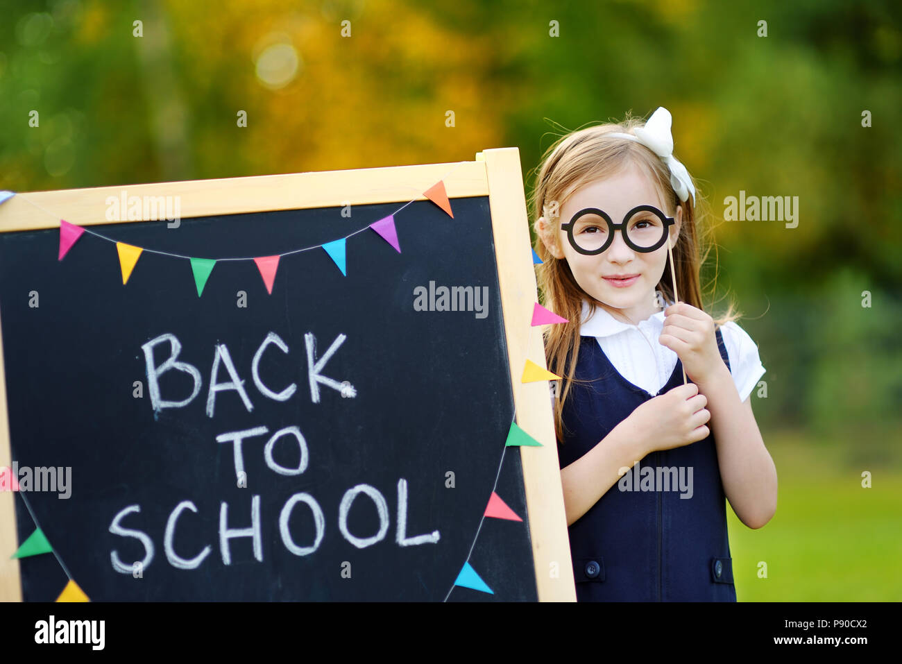 Cute little schoolgirl feeling very excited about going back to school ...