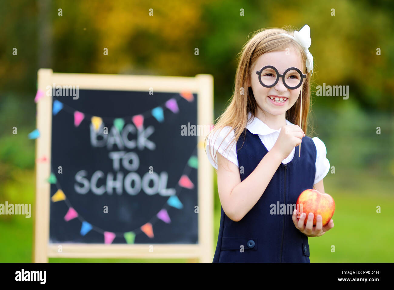 Cute little schoolgirl feeling very excited about going back to school ...
