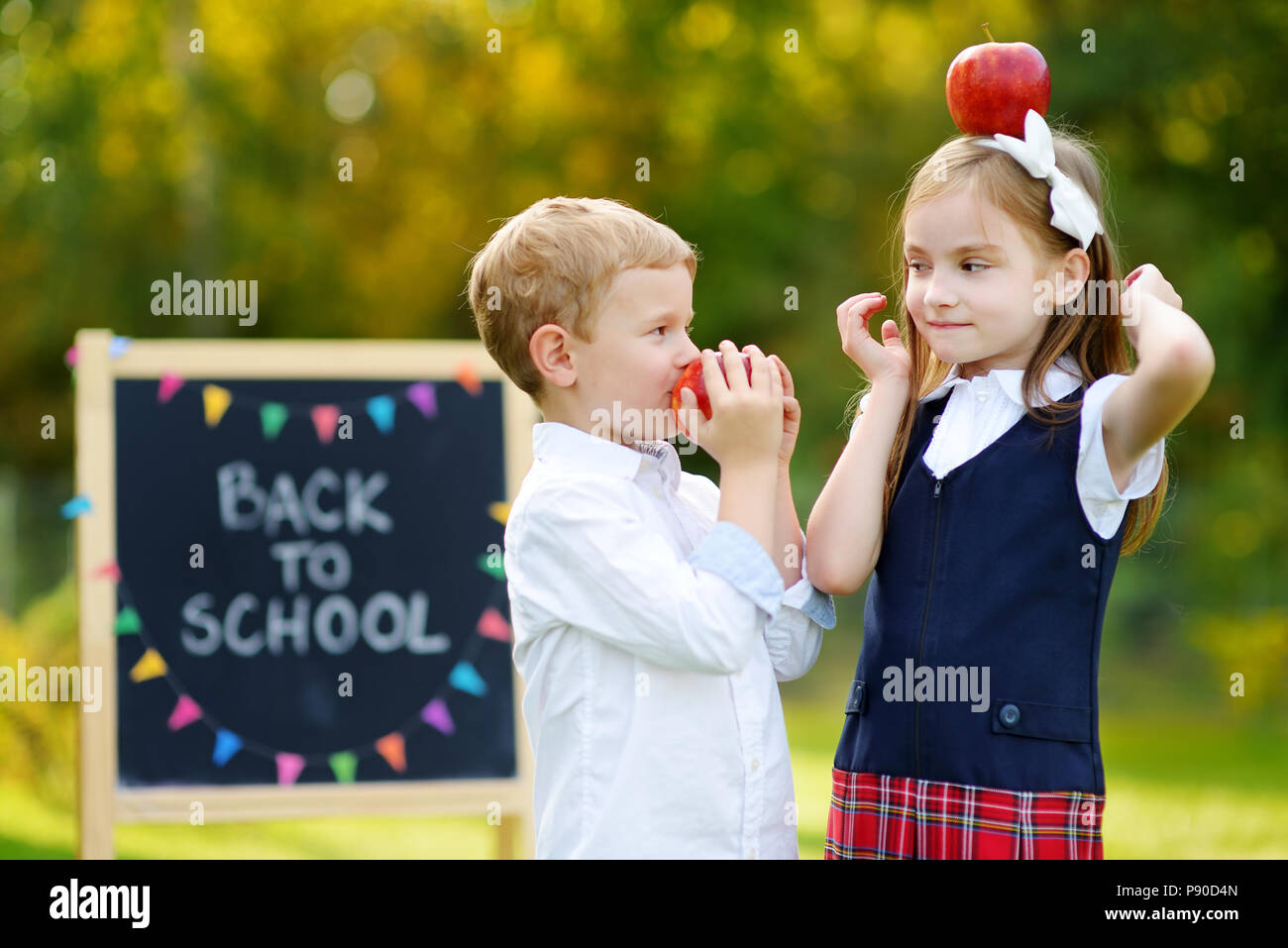 Two adorable little schoolkids feeling very excited about going back to ...