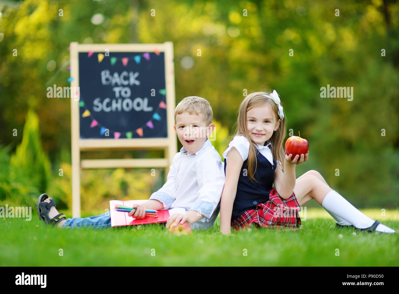 Two adorable little schoolkids feeling very excited about going back to ...