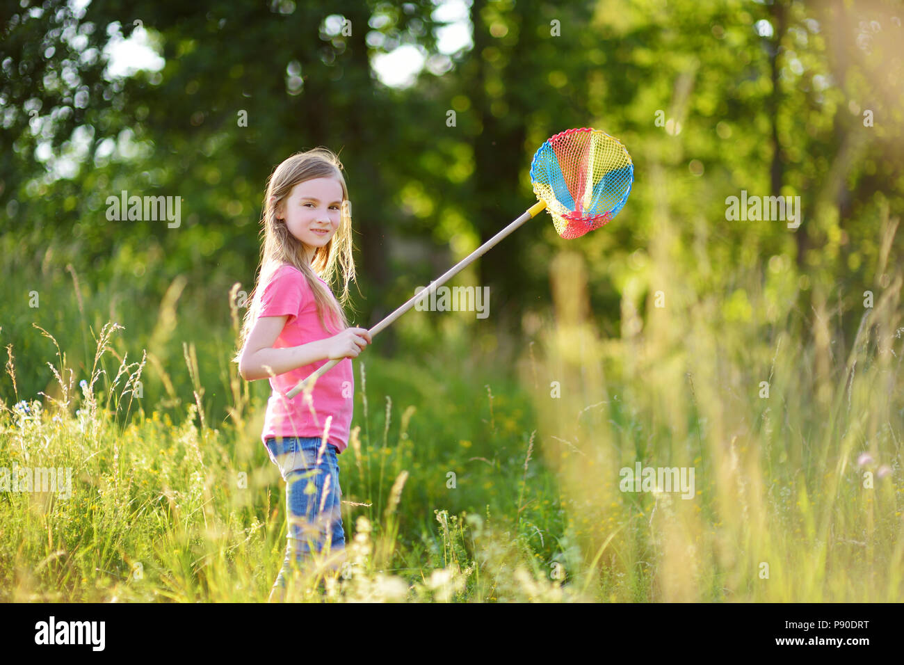 Cute little girl catching butterflies and bugs with her scoop-net on ...