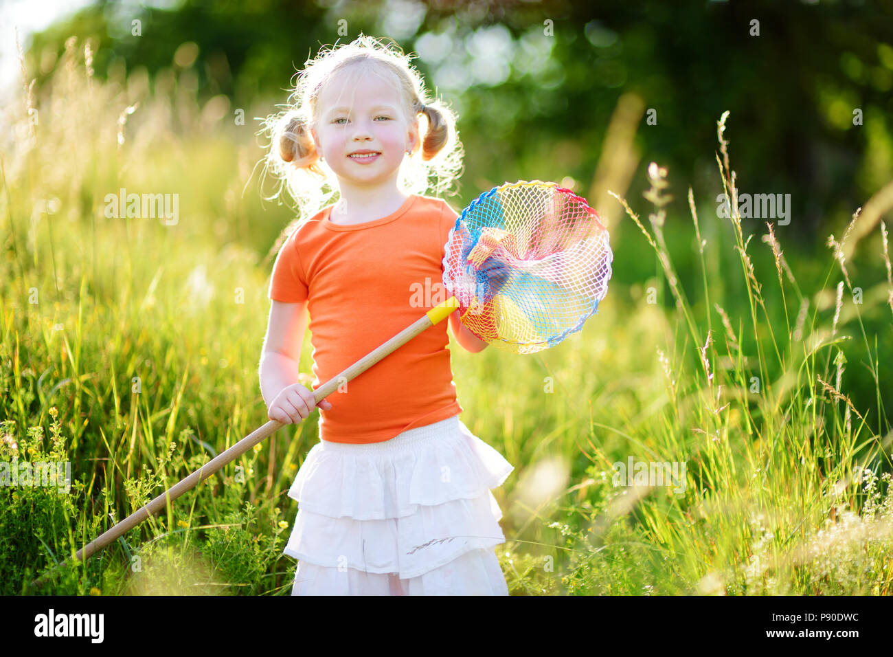 Cute little girl catching butterflies and bugs with her scoop-net on ...