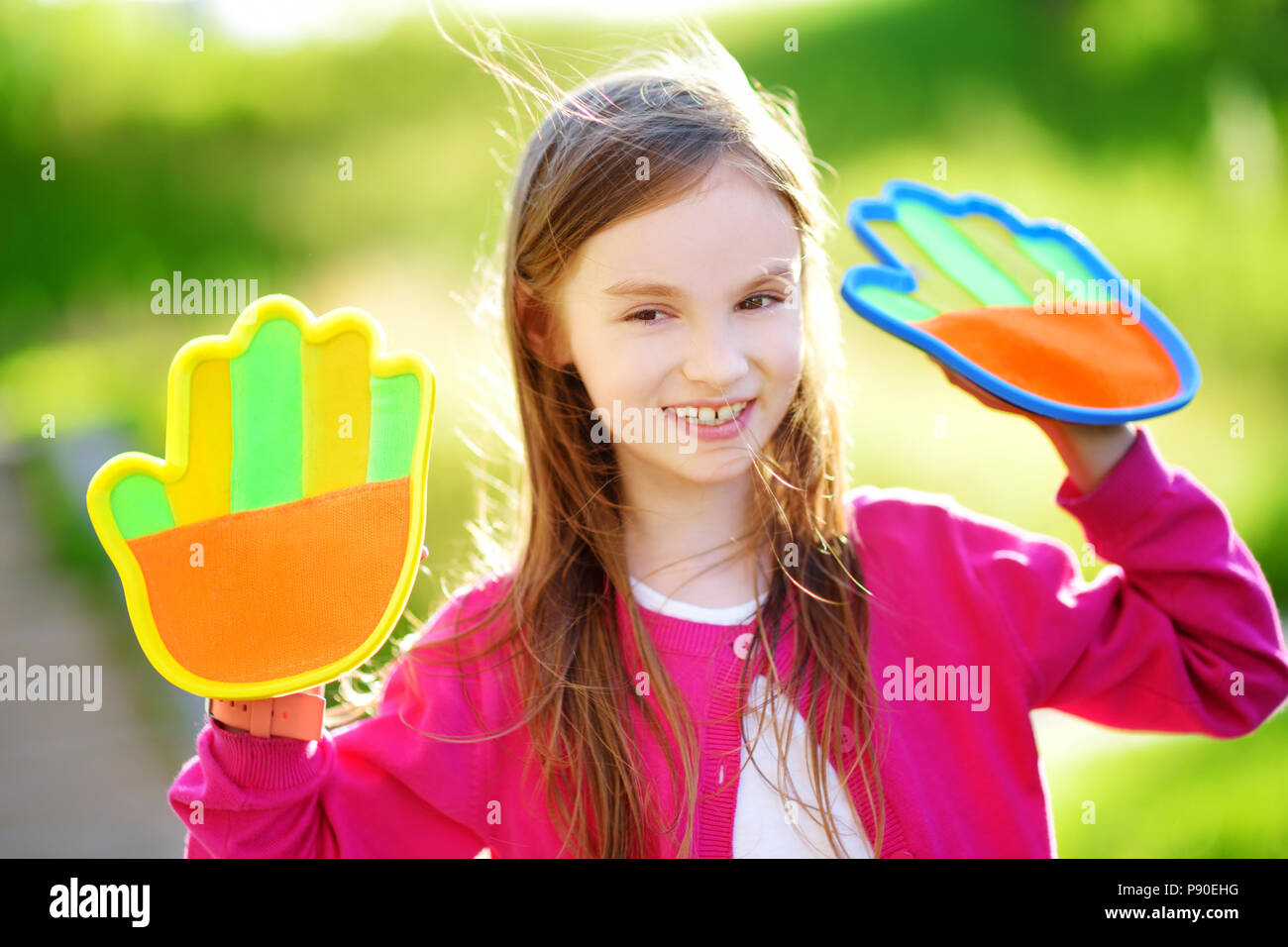 Cute little girl playing a ball catching game with sticky velcro palm ...