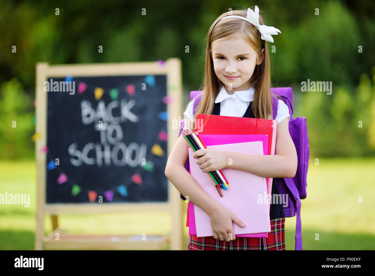 Adorable little girl feeling very excited about going back to school ...