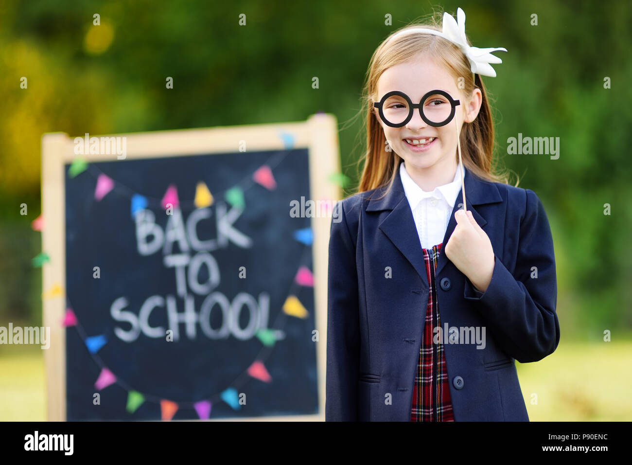 Adorable little girl feeling very excited about going back to school ...