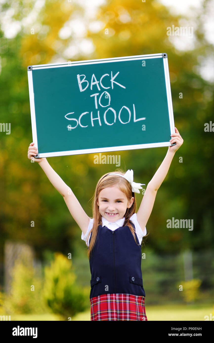 Adorable little girl feeling very excited about going back to school ...
