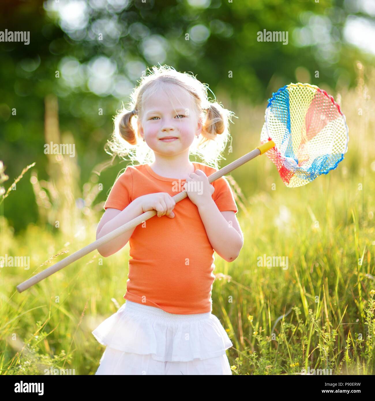 Cute little girl catching butterflies and bugs with her scoop-net on ...