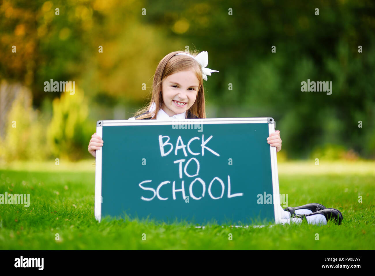 Adorable little girl feeling very excited about going back to school ...