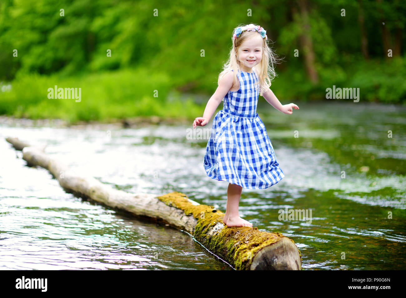Cute little girl having fun by a river on warm and sunny summer day Stock Photo - Alamy