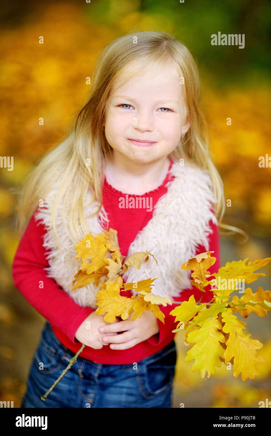 Cute little girl having fun on beautiful autumn day outdoors Stock Photo - Alamy