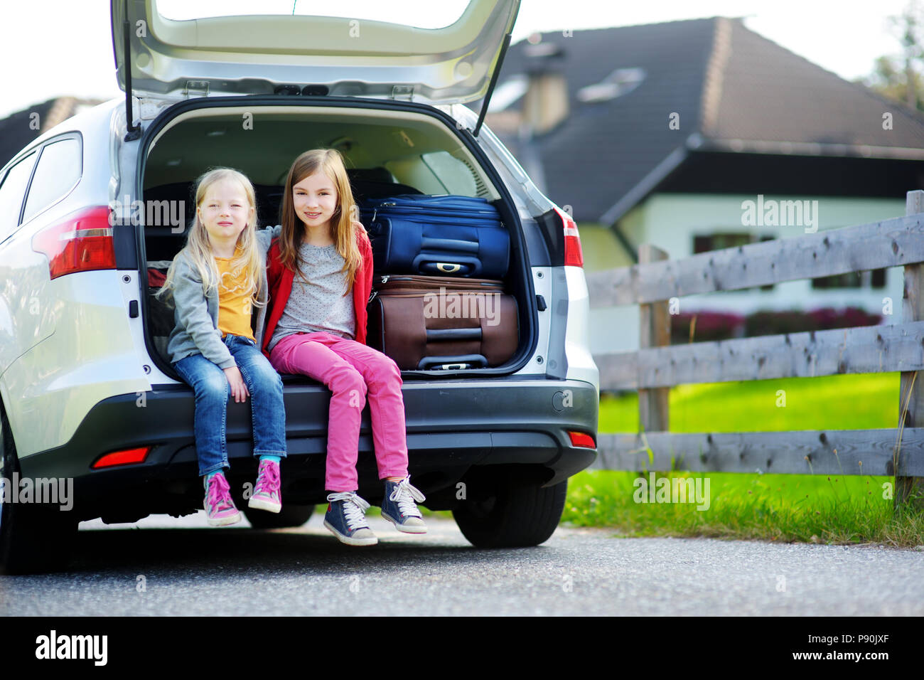 Two adorable little sitting in a car before going on vacations with ...