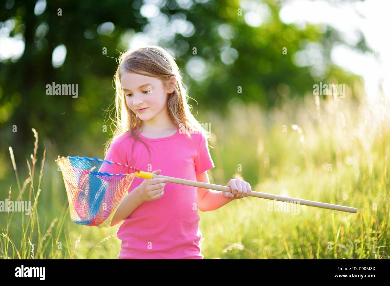 Cute little girl catching butterflies and bugs with her scoop-net on ...