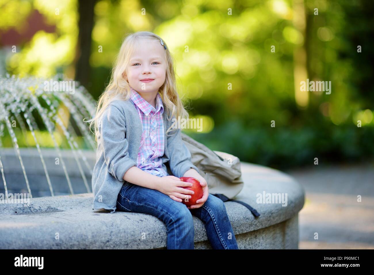 Adorable little schoolgirl in a city park on bright autumn day Stock ...