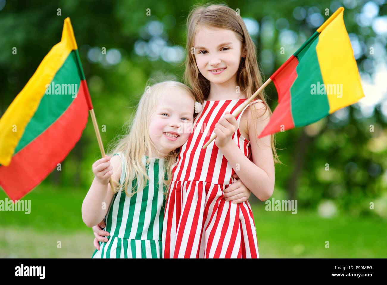 Two pretty little sisters holding tricolor Lithuanian flags on ...