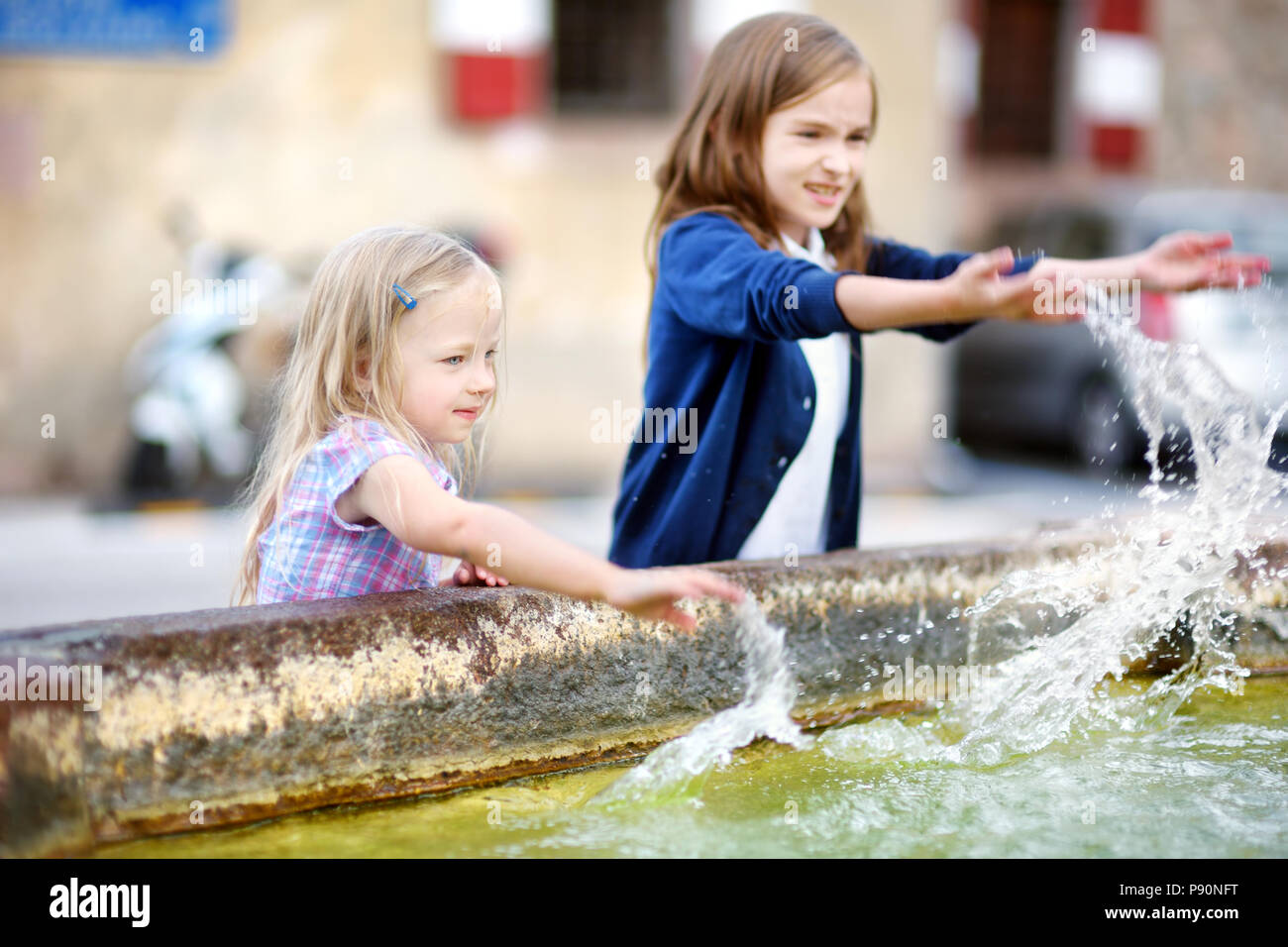 Young girls playing with the fountain hi-res stock photography and ...
