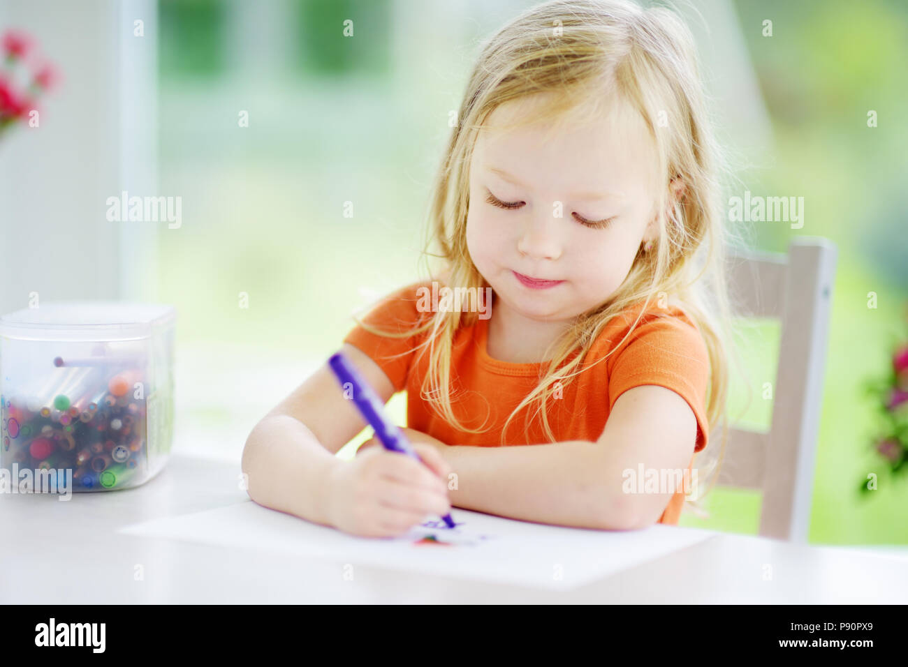 Cute little girl drawing with colorful pencils at a daycare. Creative ...