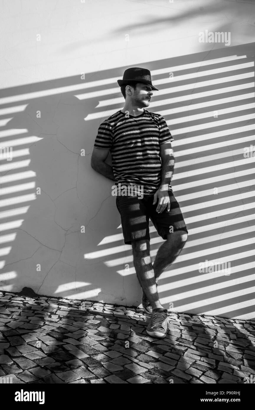 Young man leaning against the wall Stock Photo - Alamy