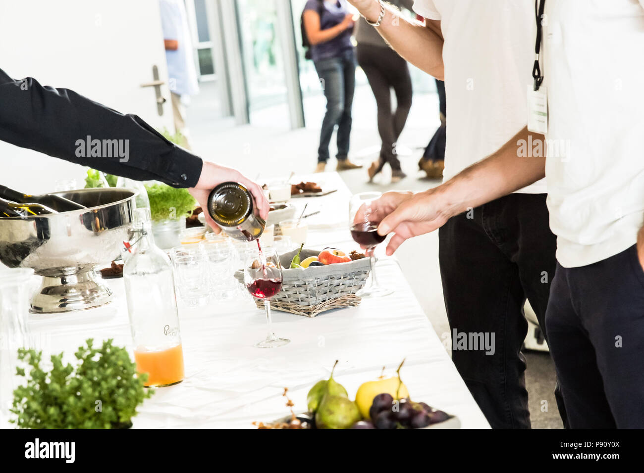 Waiter Pouring Red Wine Glass to Two Men on White Buffet Table Stock ...