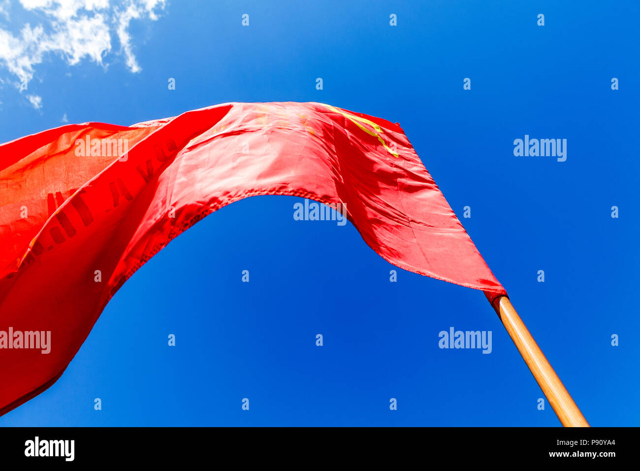 Red communist flag of the USSR against the blue sky with white clouds ...