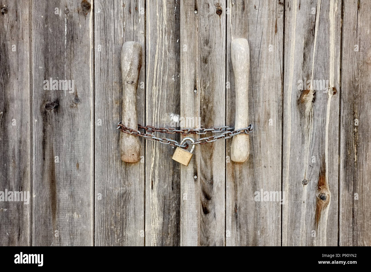 Old wooden barn door locked with rusty chain and padlock Stock Photo ...