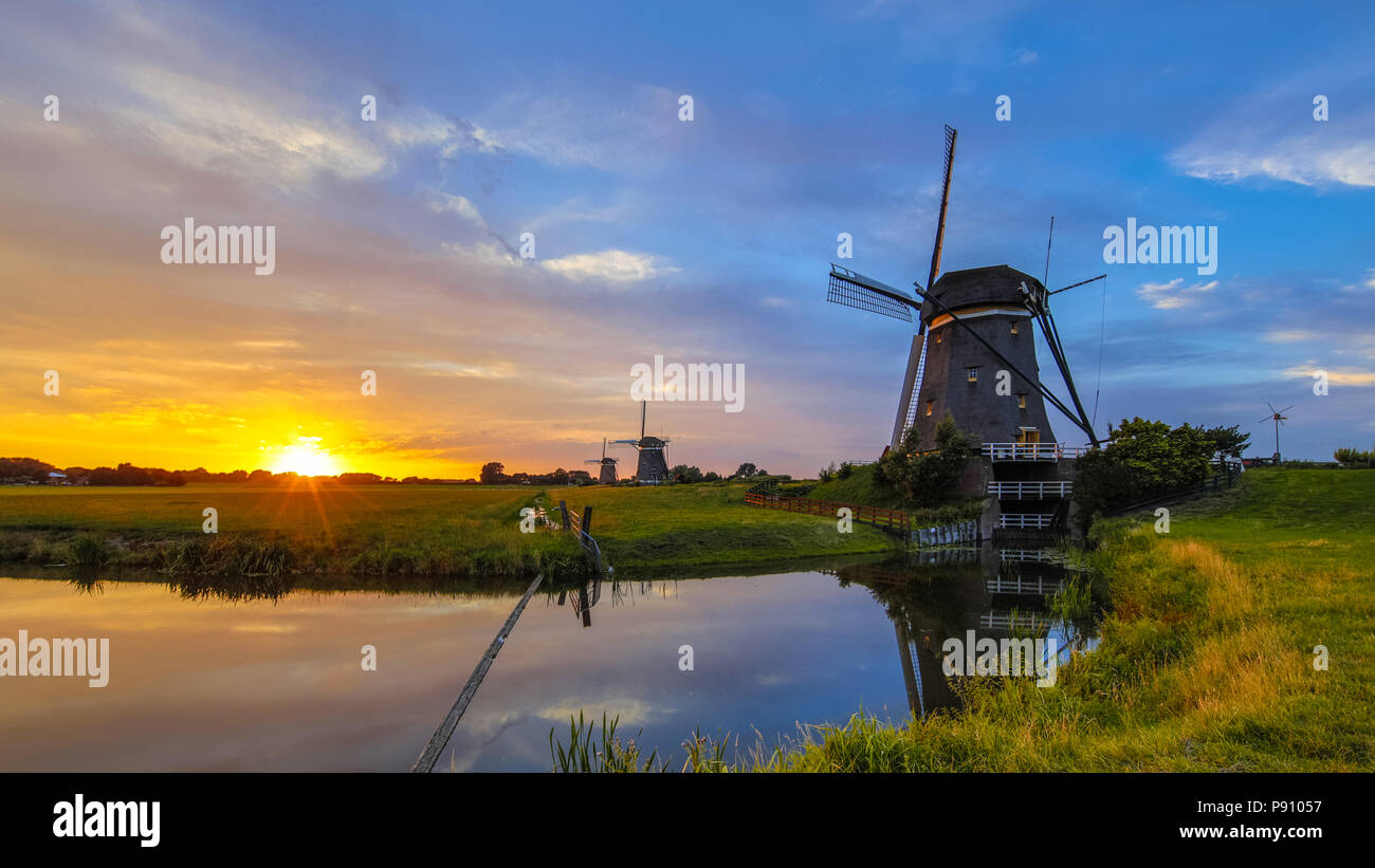 Three historic dutch wooden windmills at sunset in dutch polder landscape Stock Photo - Alamy